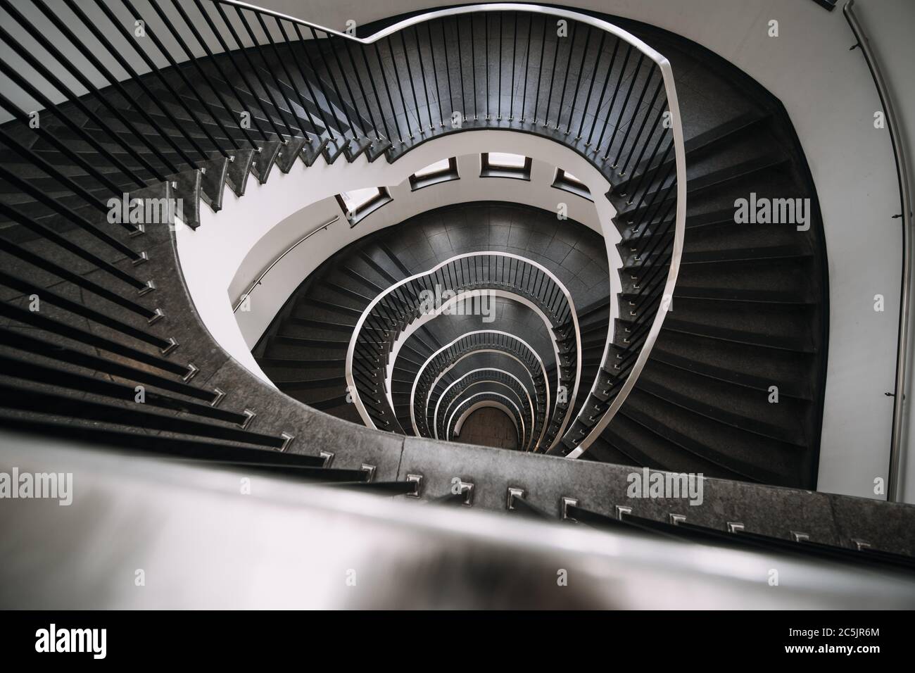 looking deep into long spiral stair case of big building, concept photo ...