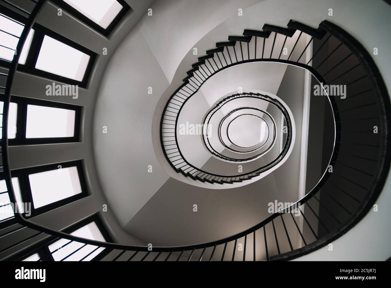 looking deep into long spiral stair case of big building, concept photo ...