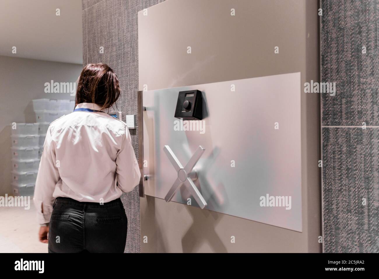 Woman entering codes into various access devices for opening the safe ...