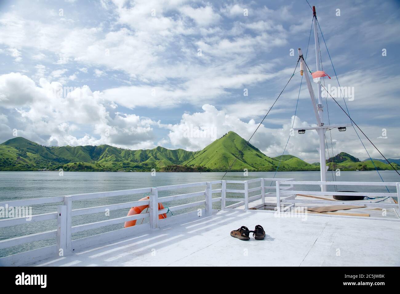 The deck of a small boat on a background of green hills. Lesser Sunda ...