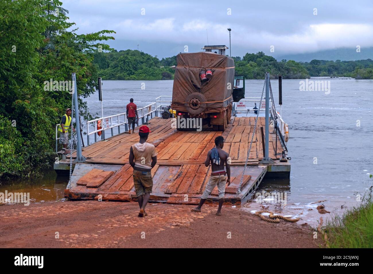 Truck on ferry boat crossing the Essequibo river in the rainy season ...