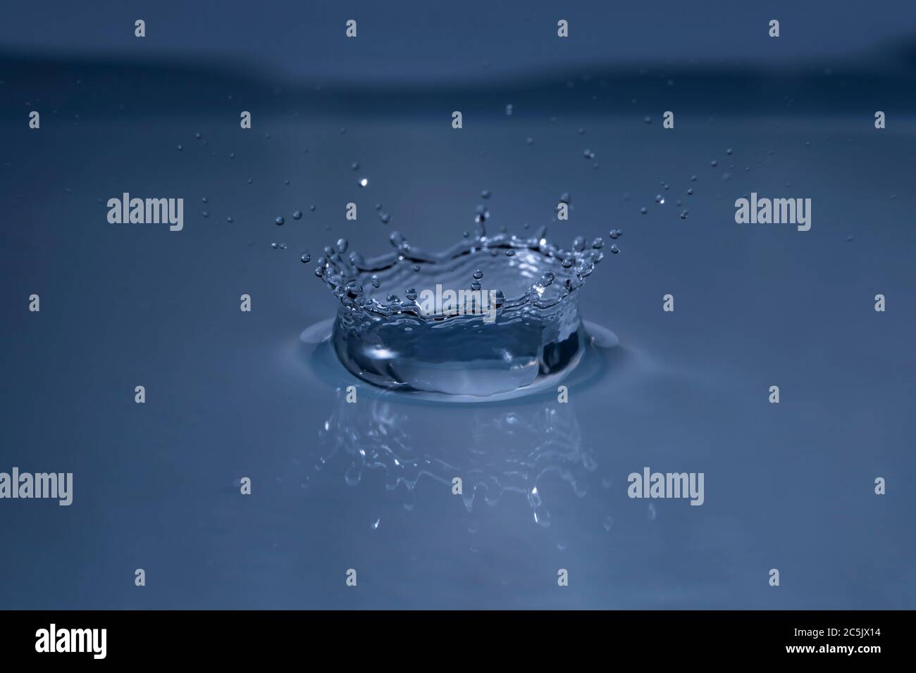 Splashing water drop hitting water surface Stock Photo - Alamy