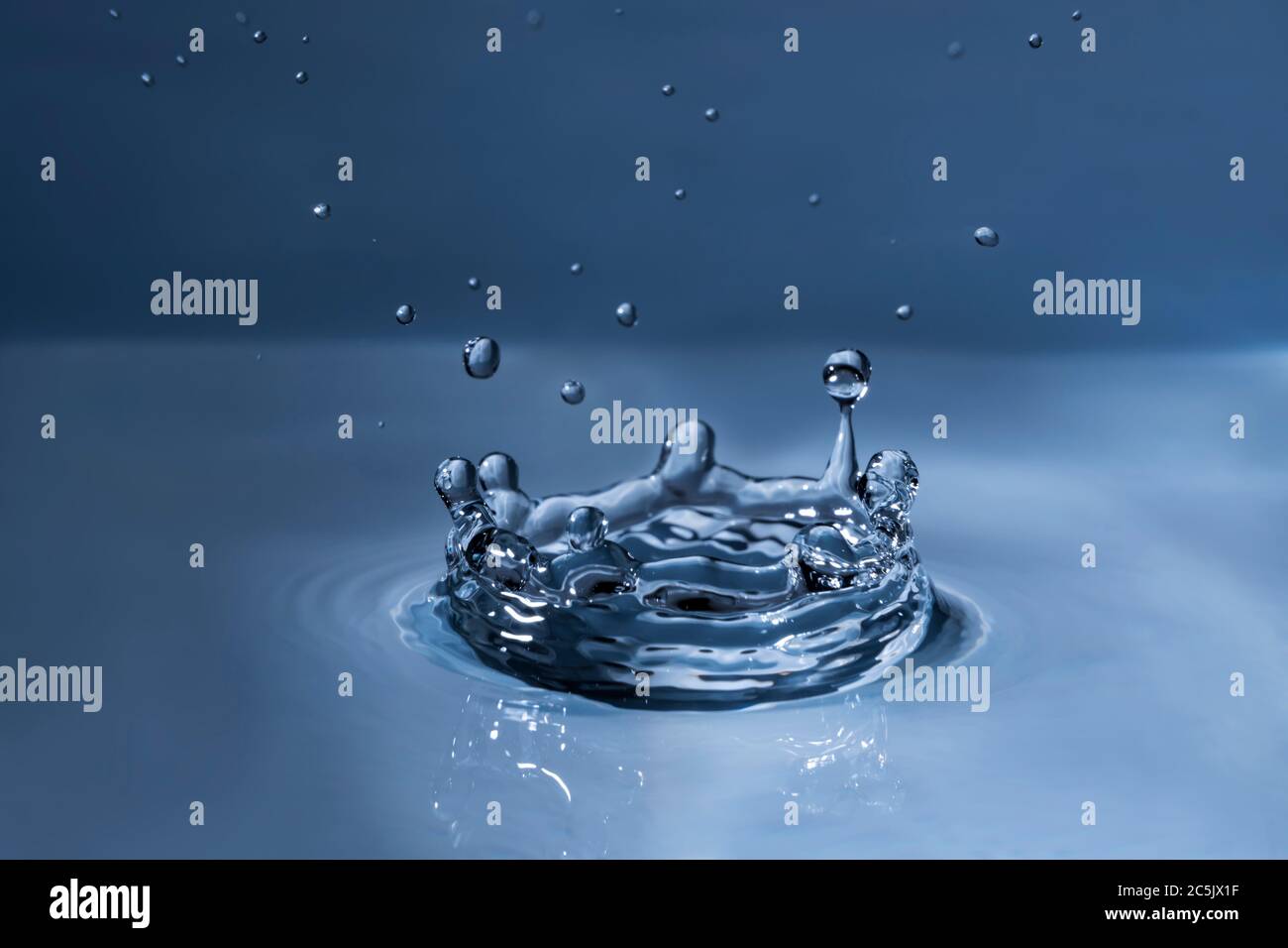 Splashing water drop hitting water surface Stock Photo - Alamy