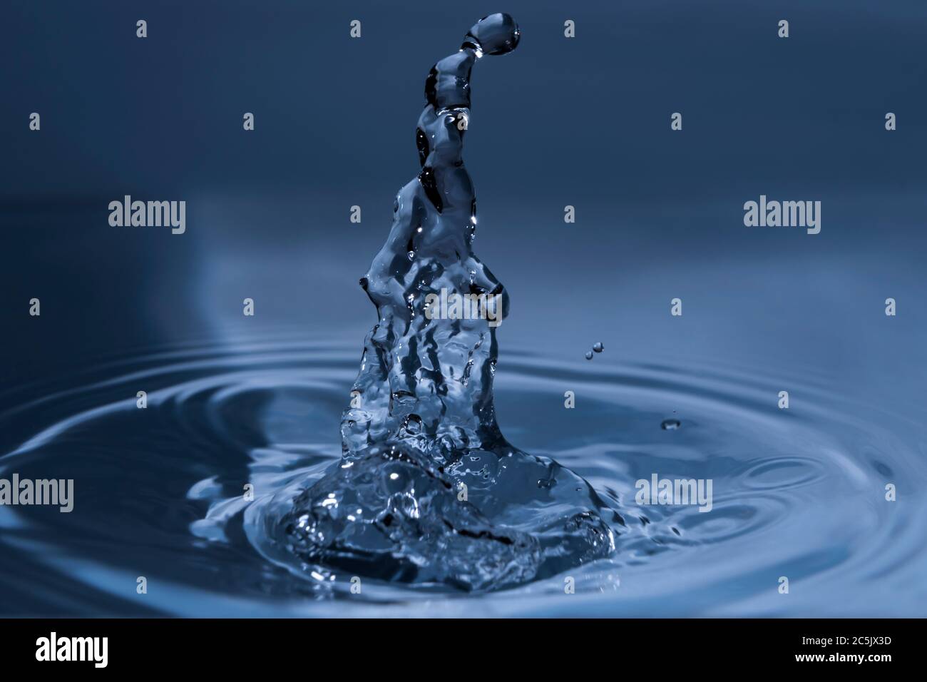 Splashing water drops causing wavy water surface and water column Stock ...