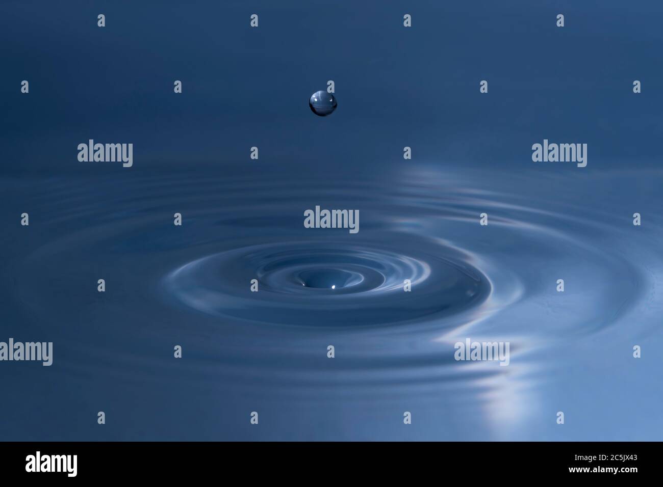 Water drop above wavy surface Stock Photo - Alamy