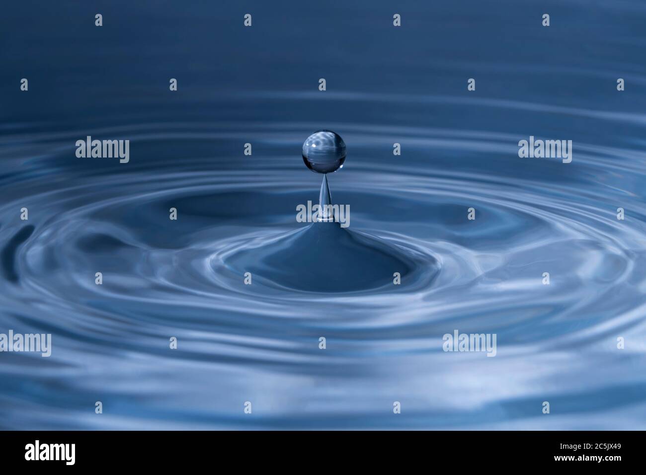 Water drop rising again after dipping into water Stock Photo - Alamy