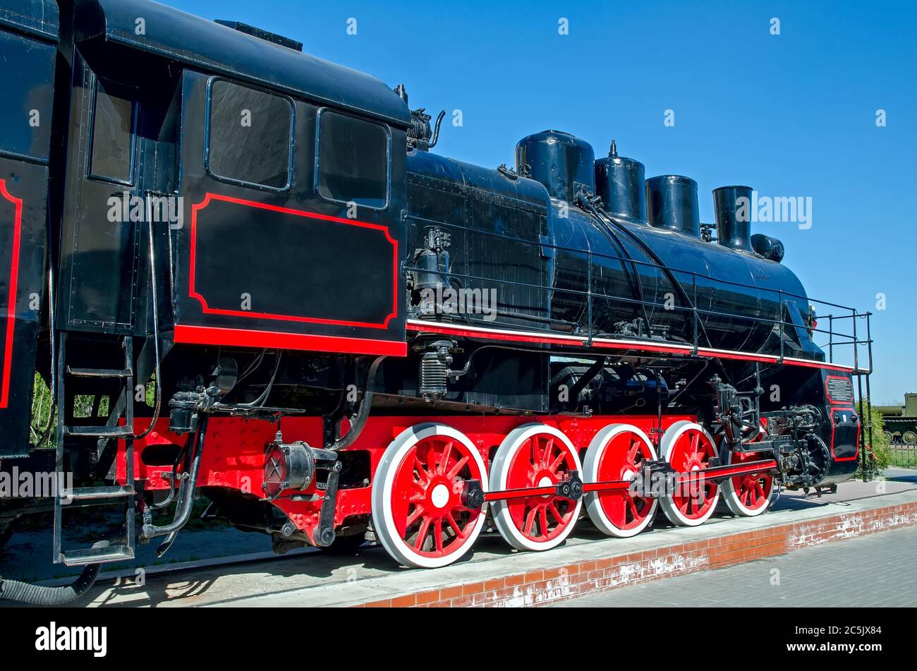 Old Russian (Soviet) steam locomotive on a pedestal on a background of ...