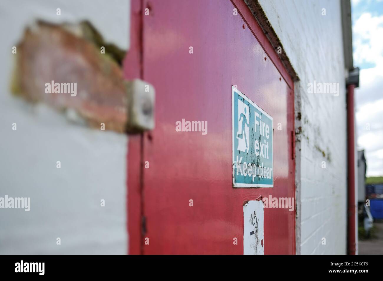 Shallow focus of an old Fire Exit and No Smoking sign seen attached for ...