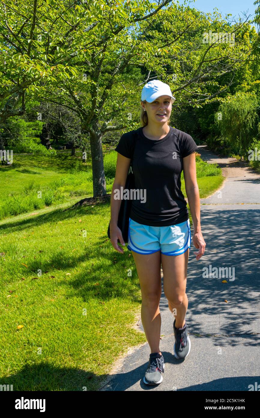 Photo of a young woman taking a walk in a park on a beautiful summer ...