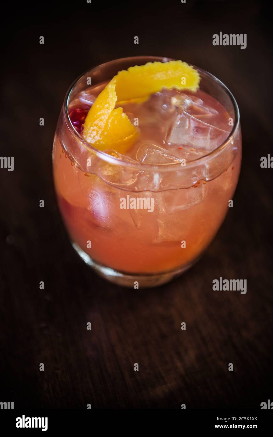 Pink cocktail with lemon and cherry garnish Stock Photo - Alamy