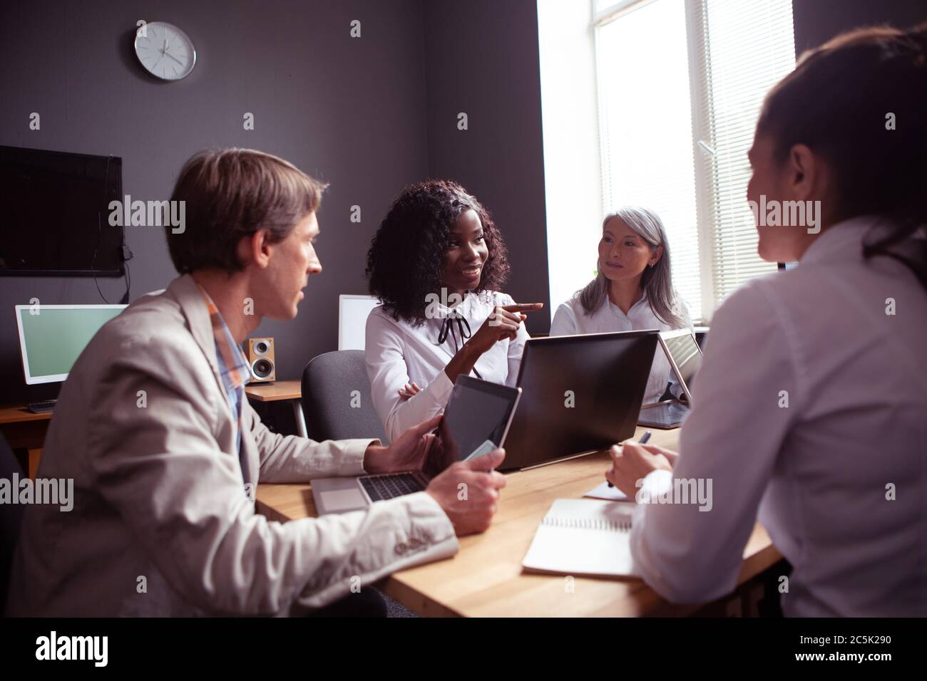 Pretty African woman speaker speaks, gesturing and pointing at someone ...