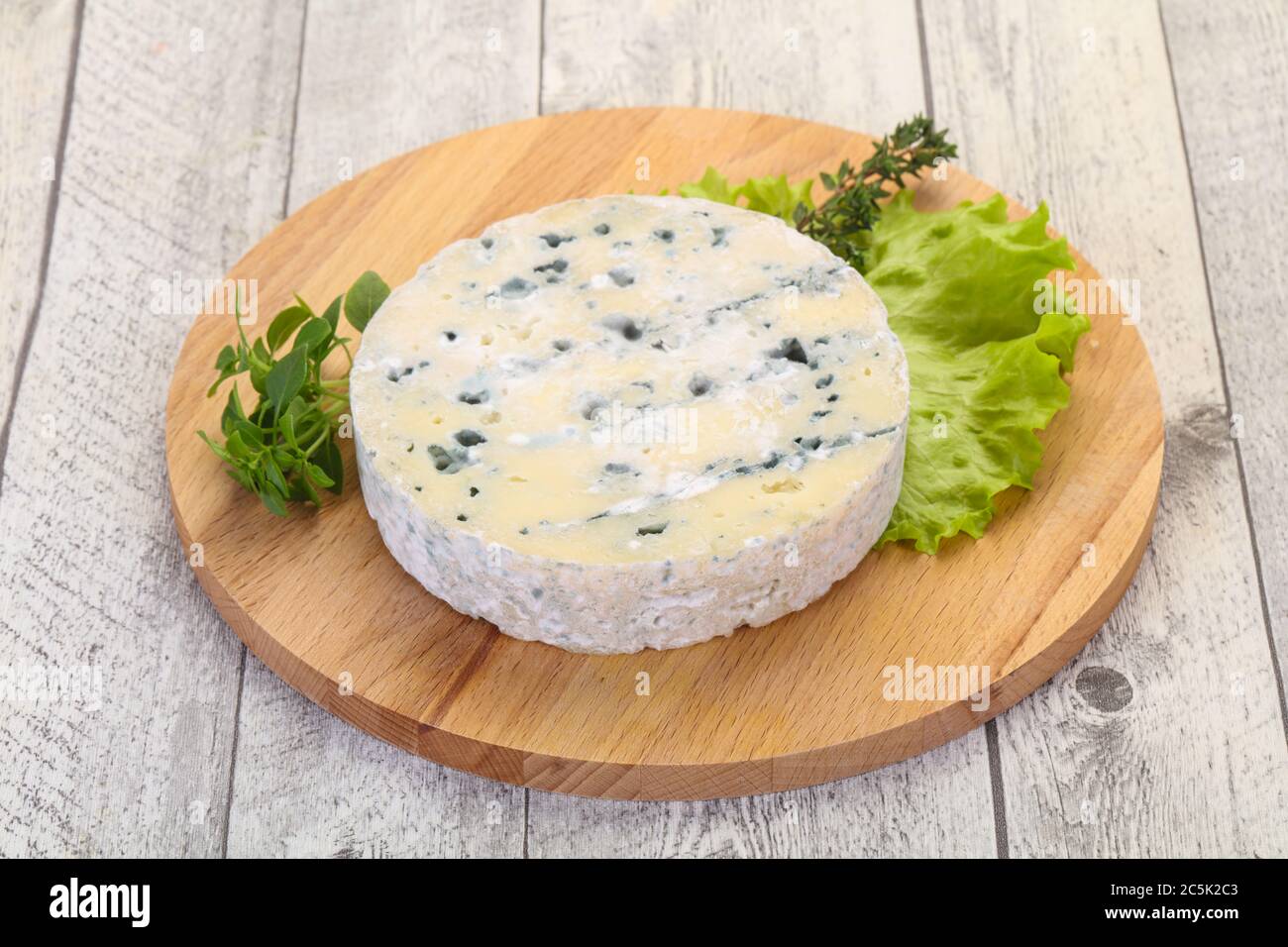 Round blue cheese with salad and basil Stock Photo - Alamy