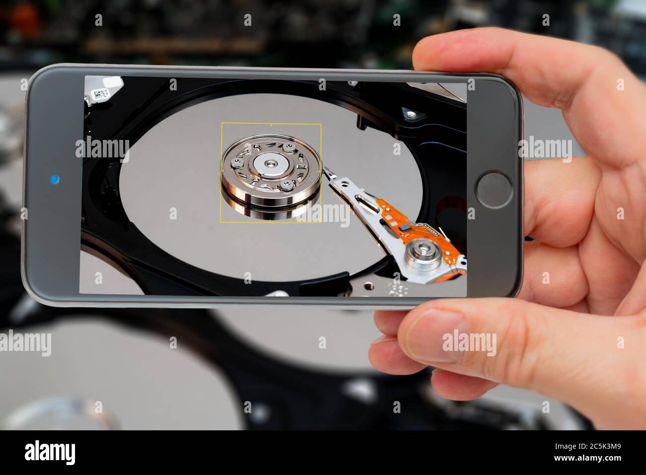 Computer hard drive on smartphone screen. Repair of electronic devices ...