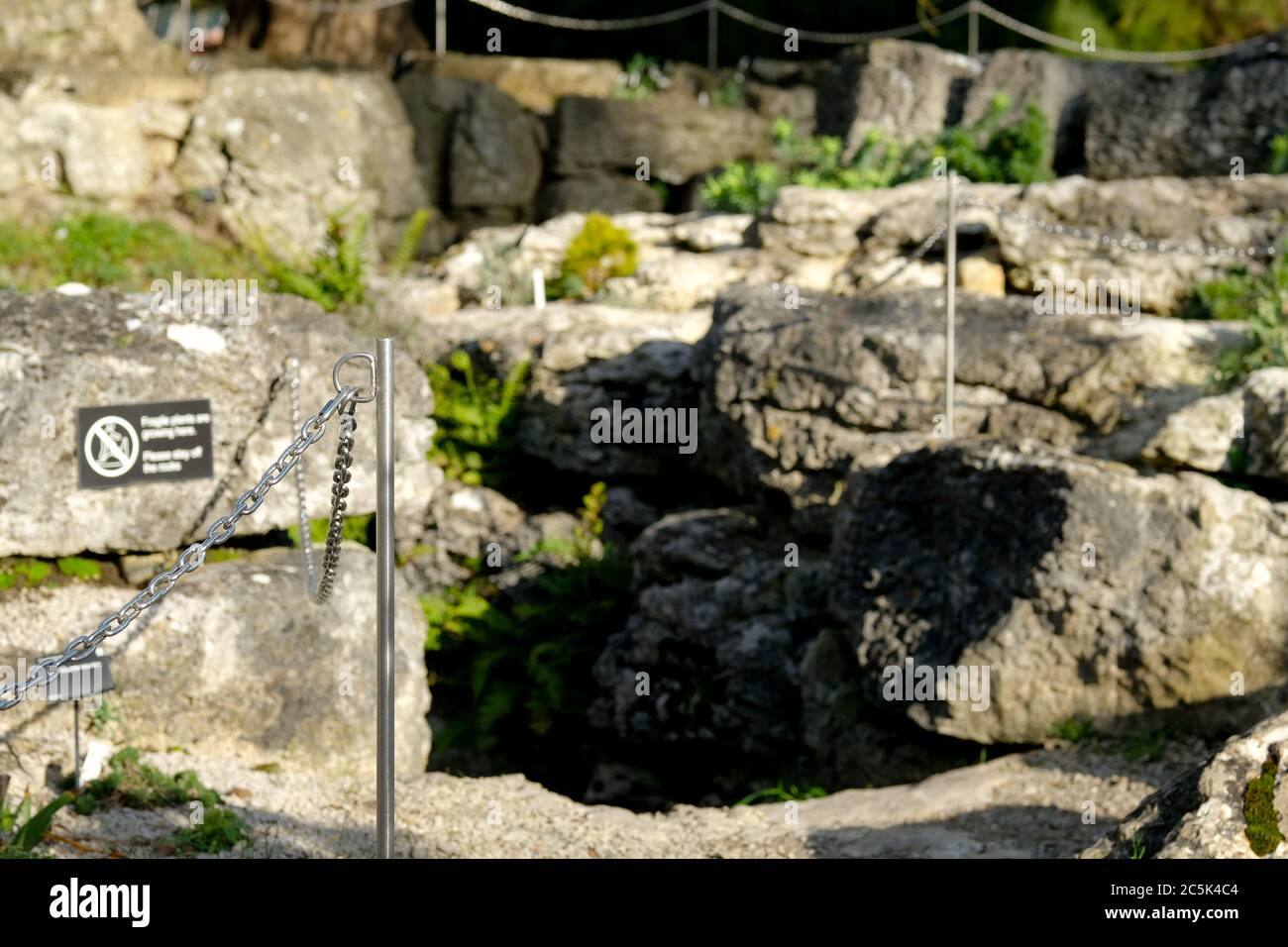 Shallow focus of a metal chain barrier seen at a large garden rockery ...