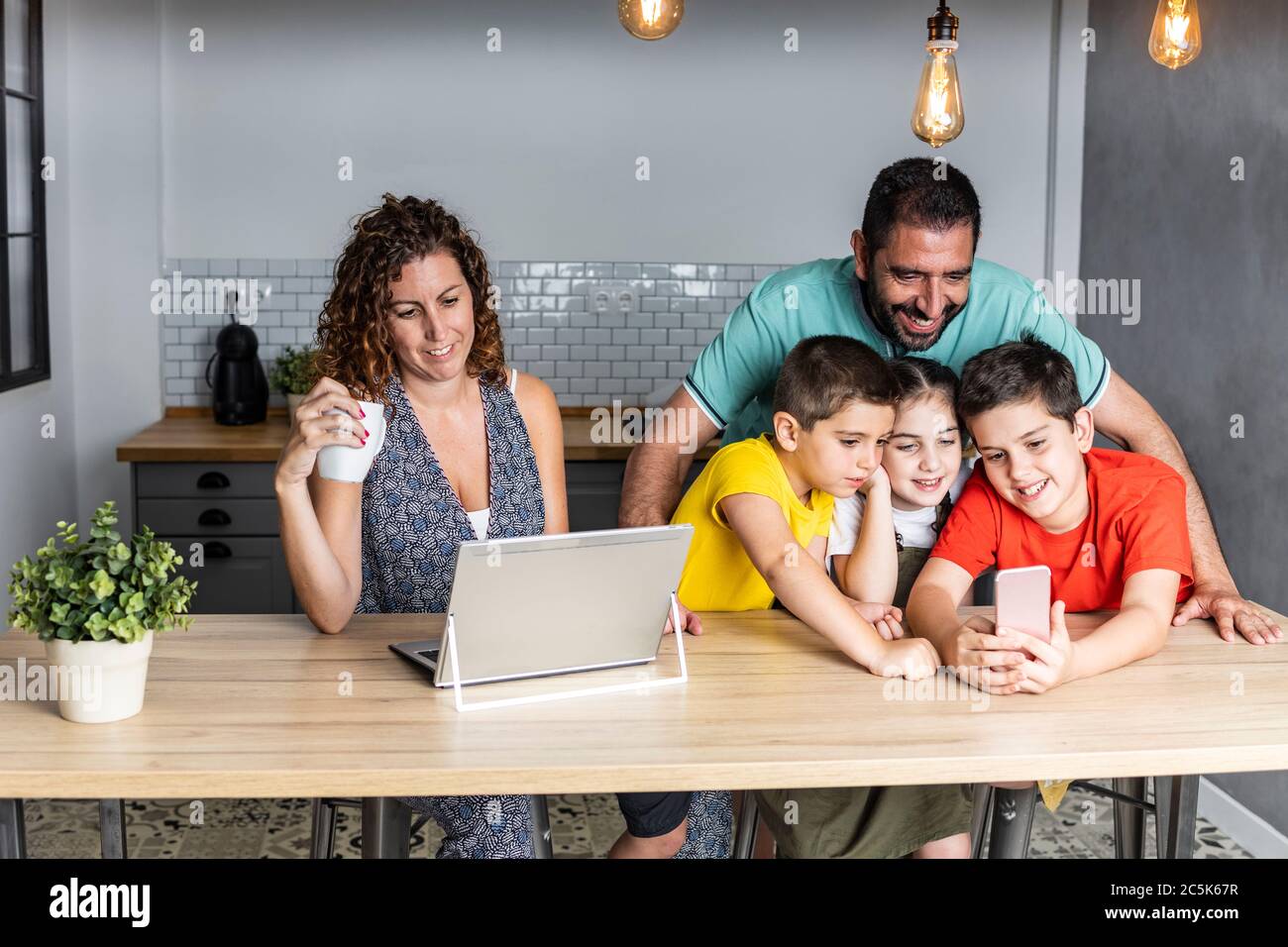 Happy large family connected to technology Stock Photo - Alamy