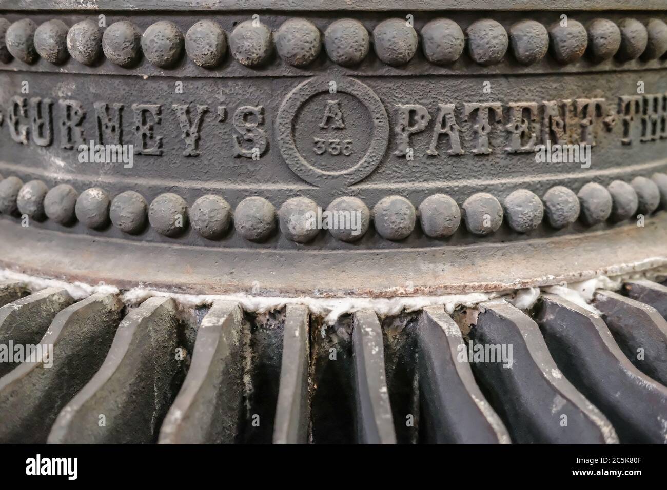 lose-up view of a very old, cast-iron gas fired boiler used to heat a ...