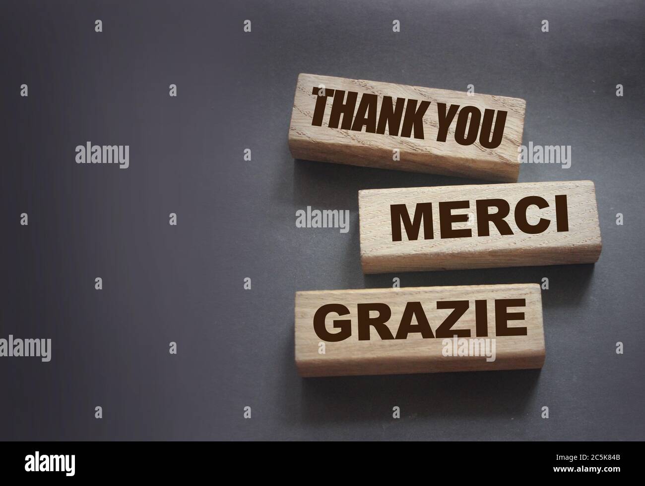 Text Thank you Merci Grazie on wooden blocks on black background ...