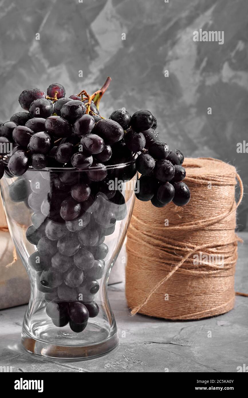 Bunches of fresh ripe dark grapes on a concrete textural surface. Red ...
