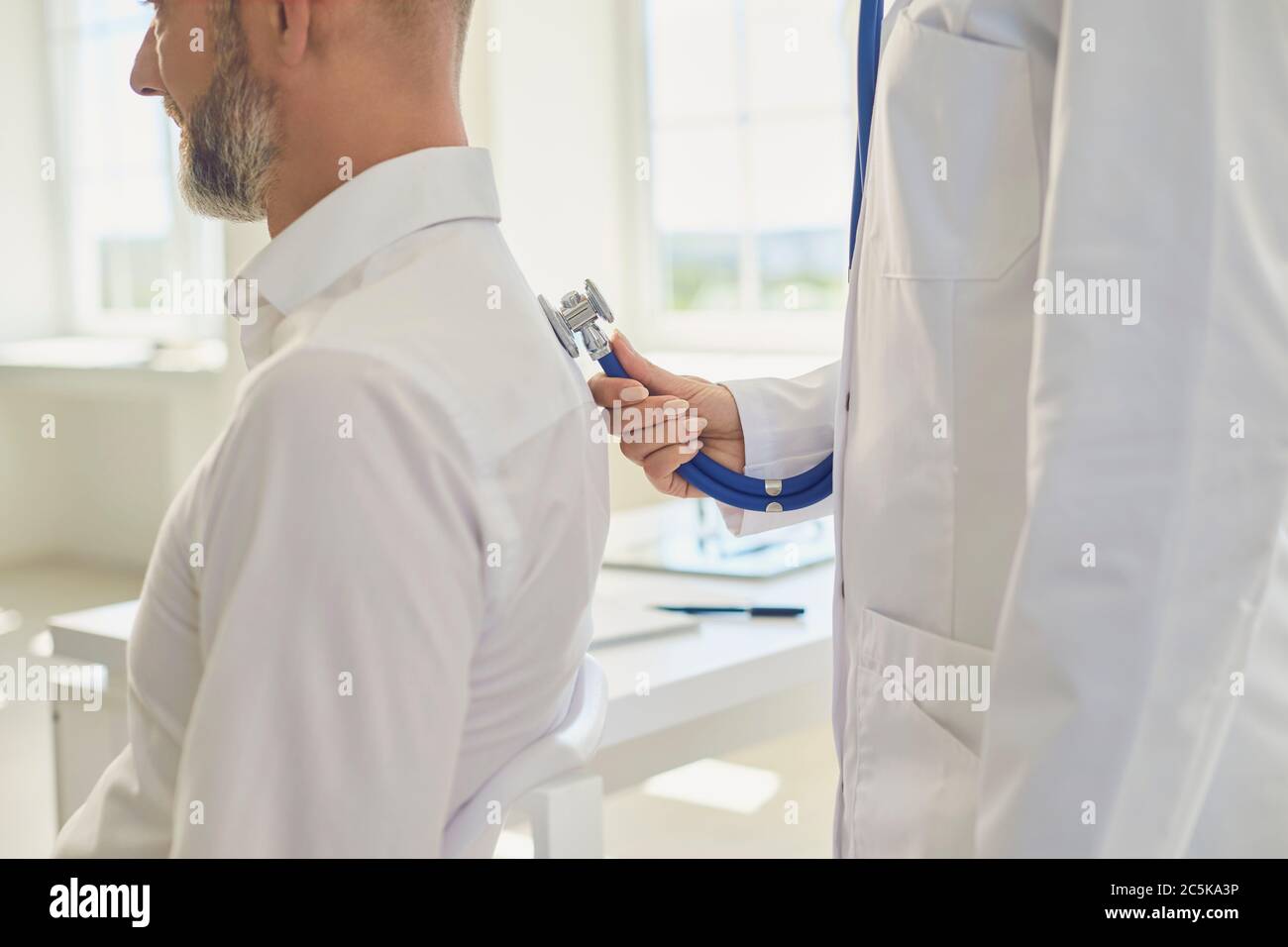 Woman doctor uses stethoscope listen hi-res stock photography and ...
