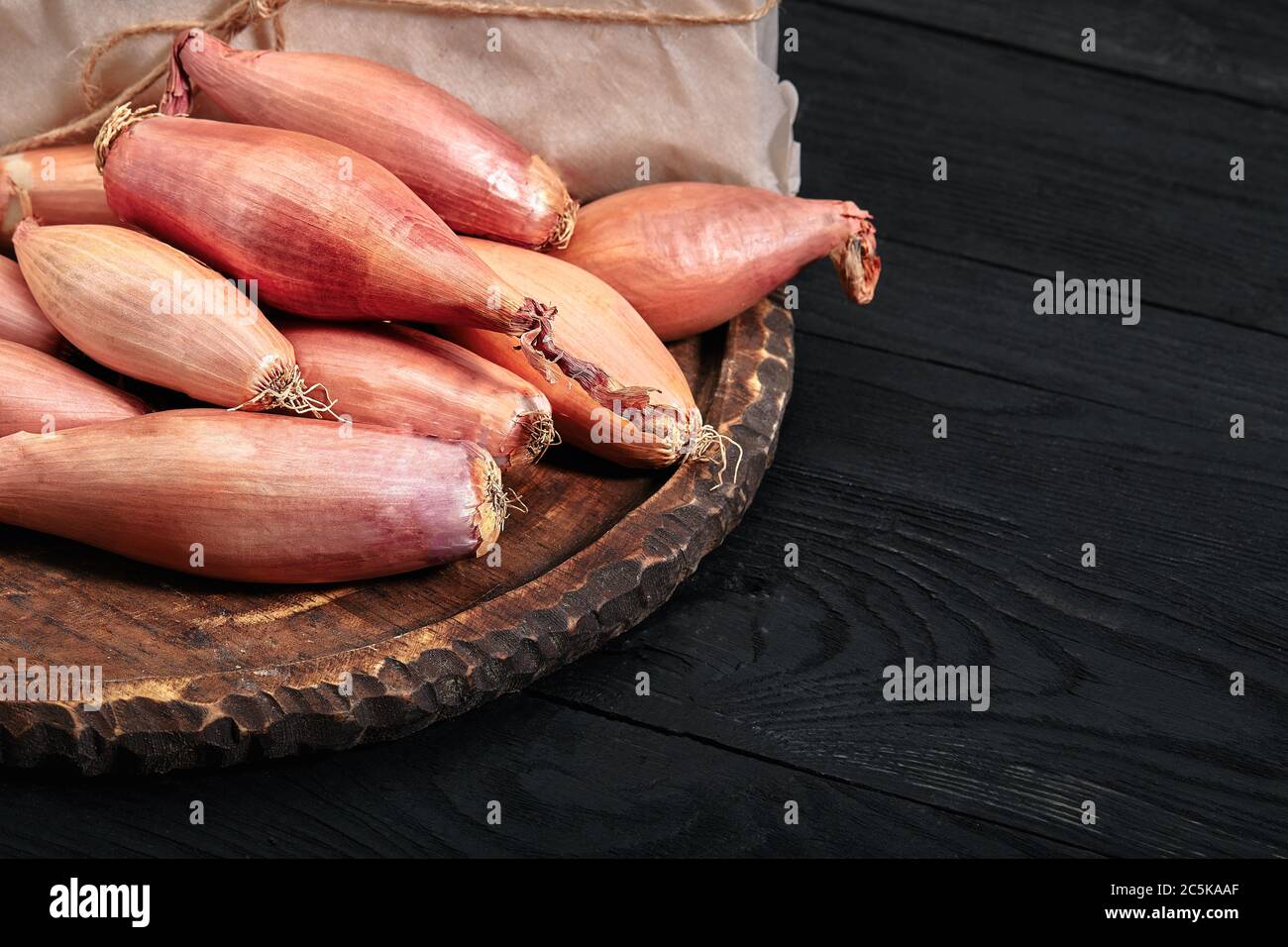 Onion shallot on a black, dark background. Eating vegetables and eating ...