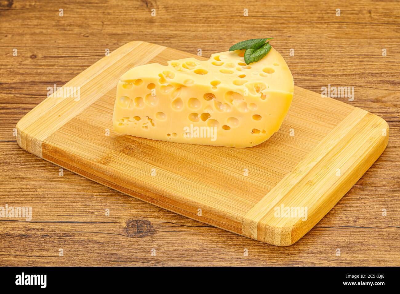 Maasdam cheese - dairy yellow triangle with holes Stock Photo - Alamy
