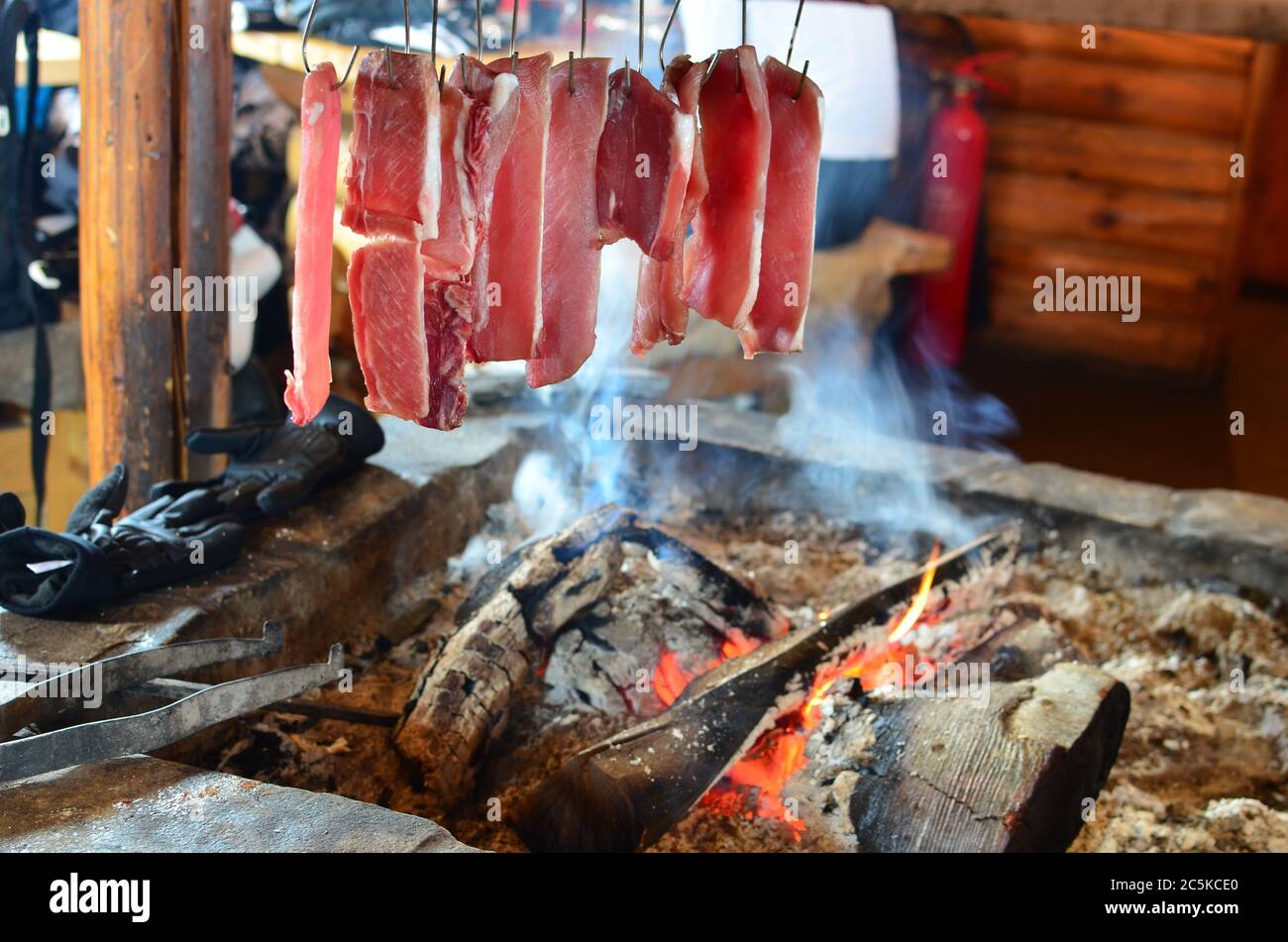 Fresh pork meat over fire in fireplace, traditional way of meat ...