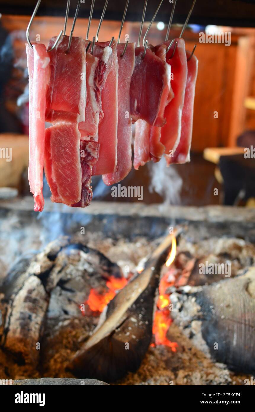 Fresh pork meat over fire in fireplace, traditional way of meat ...