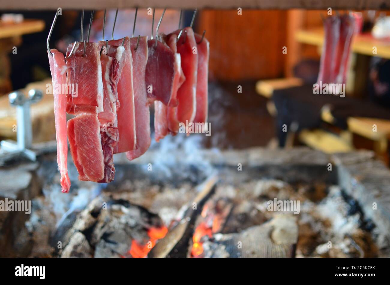 Fresh pork meat over fire in fireplace, traditional way of meat ...