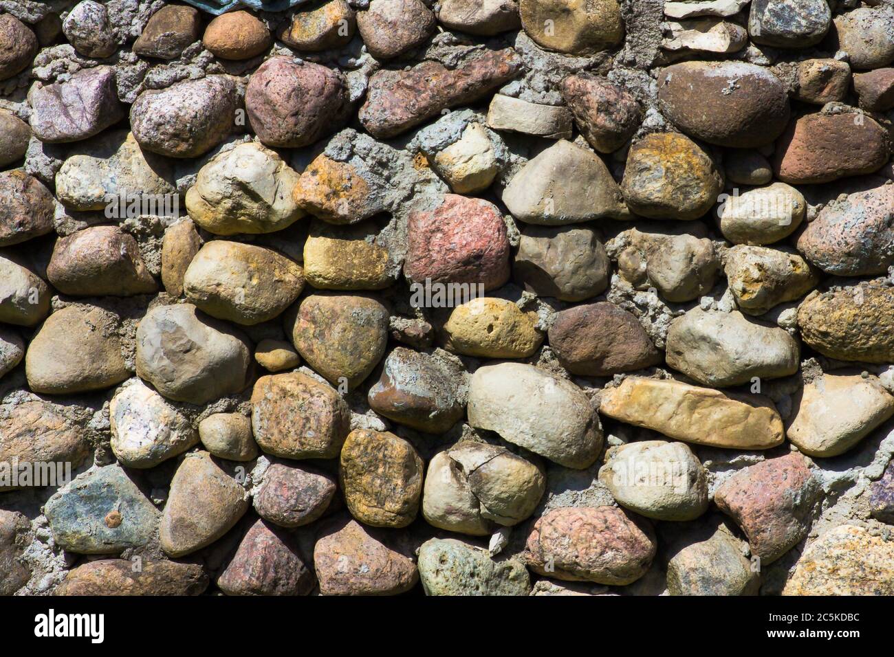 masonry with round stones on cement Stock Photo - Alamy