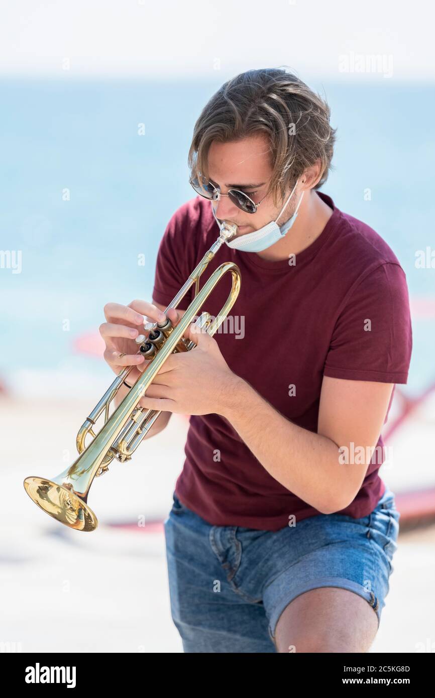 Handsome young man wearing glasses with his surgical mask pulled down ...