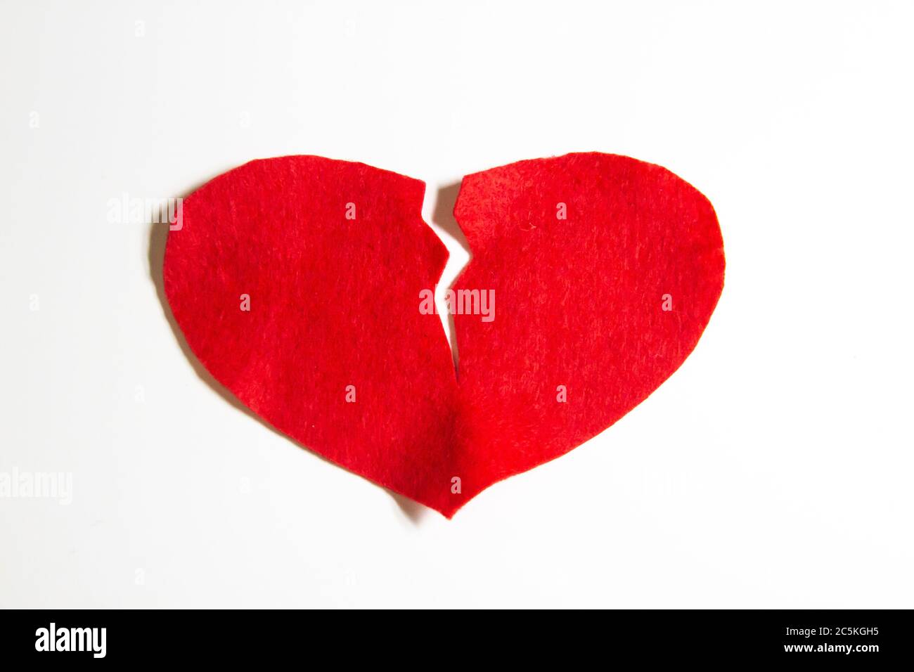 Broken red heart made of felt. Broken love concept. A broken heart ...