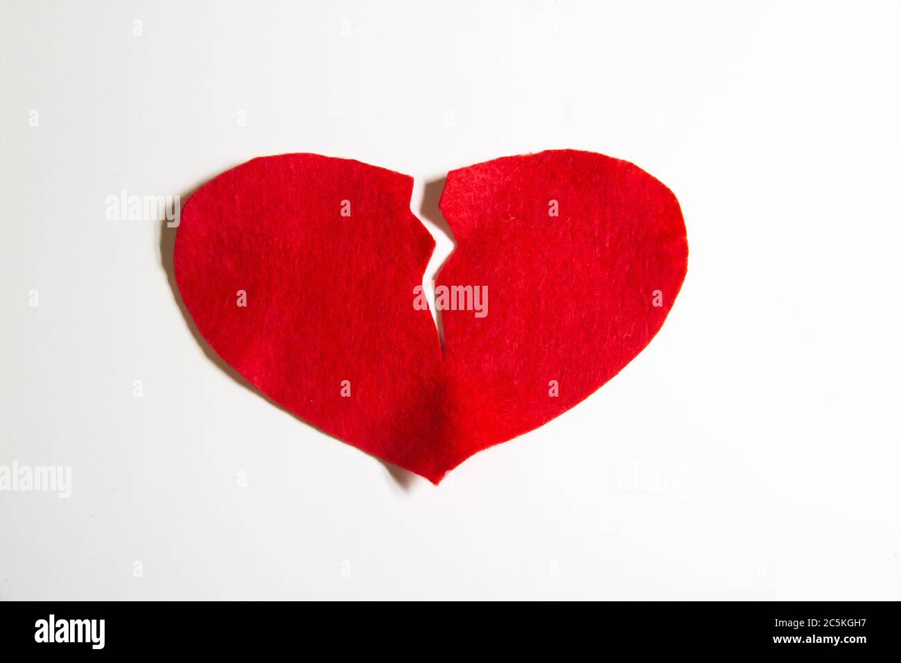 Broken red heart made of felt. Broken love concept. A broken heart ...