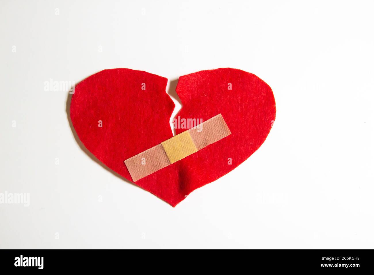 Broken heart and glued together with a band-aid. A heart from felt. A ...