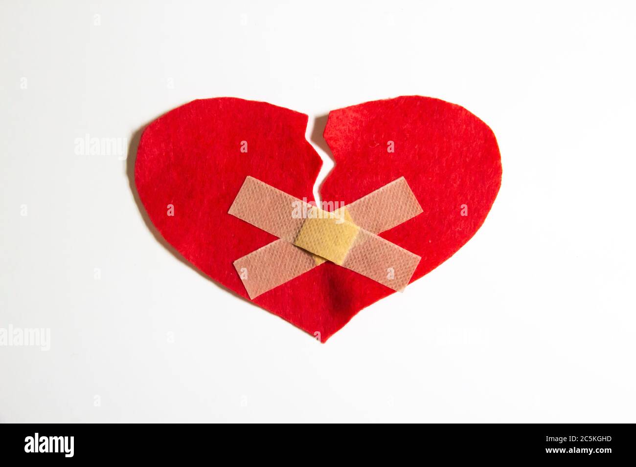 Broken heart and glued together with a band-aid. A heart from felt. A ...