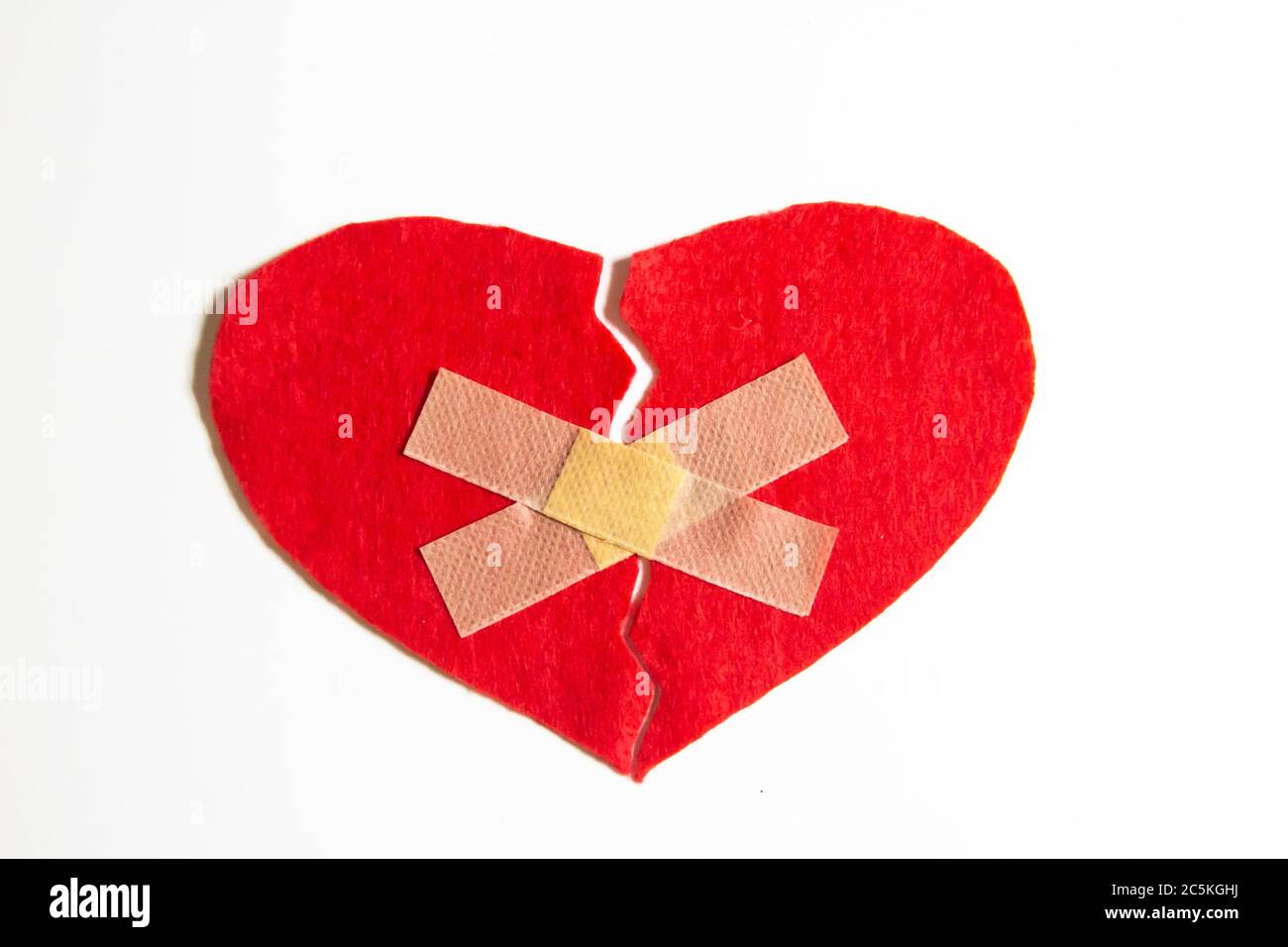 Broken heart and glued together with a band-aid. A heart from felt. A ...