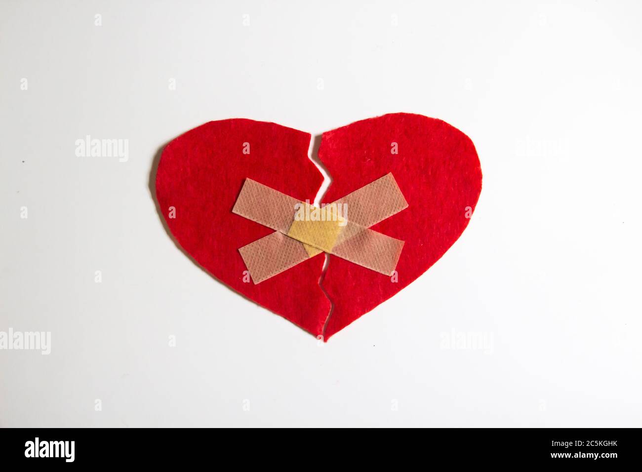 Broken heart and glued together with a band-aid. A heart from felt. A ...