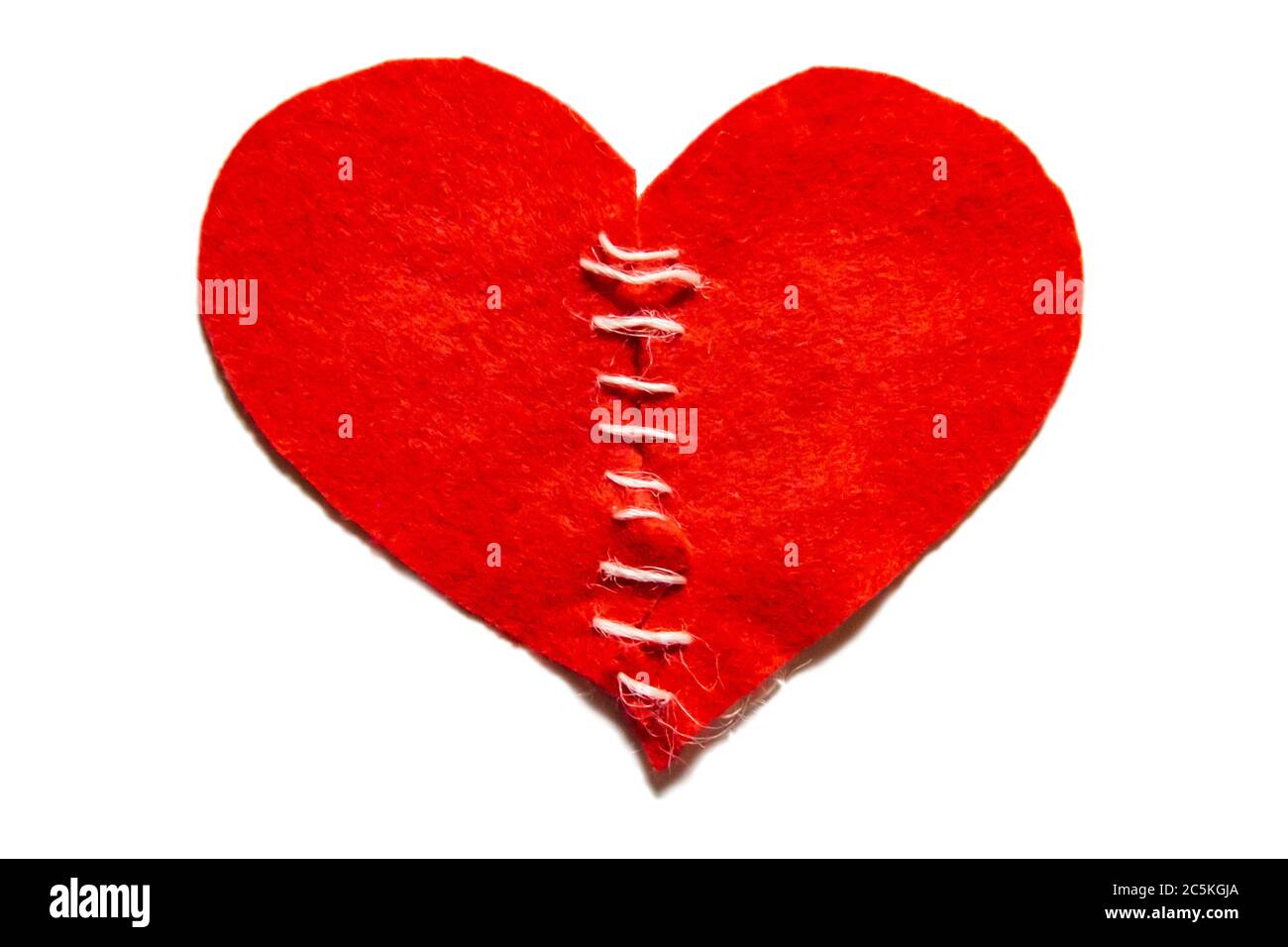 Sewed a broken heart with a thread. Red heart made of felt. Broken love ...