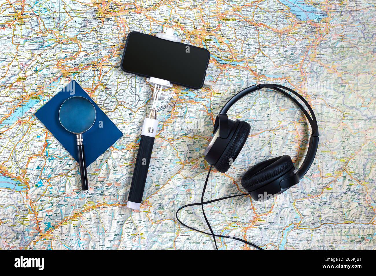 Travel accessories set on the map background: smart, headphones ...