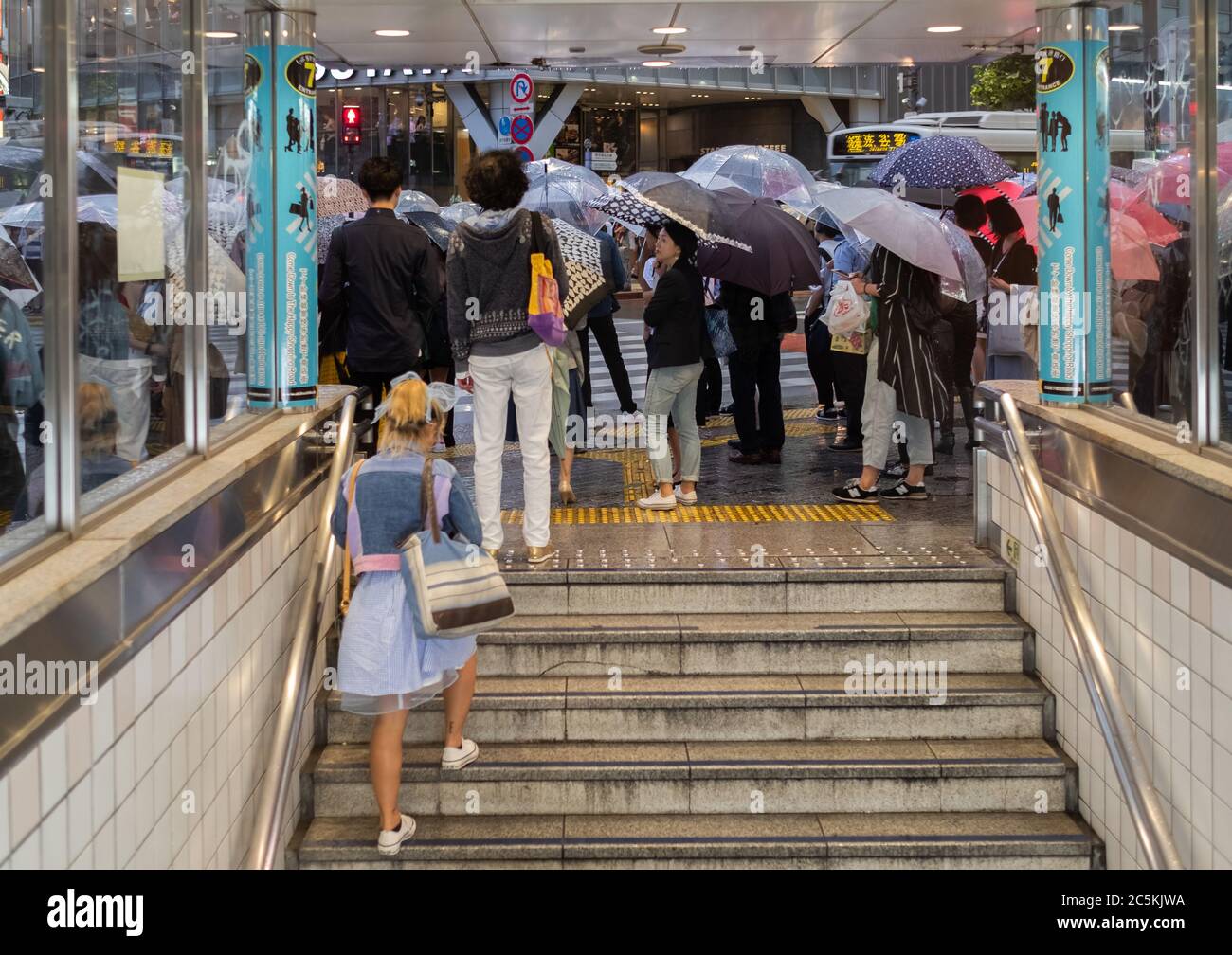 Crowd of people at Tokyo Metro exit stairs, during a rainy night ...
