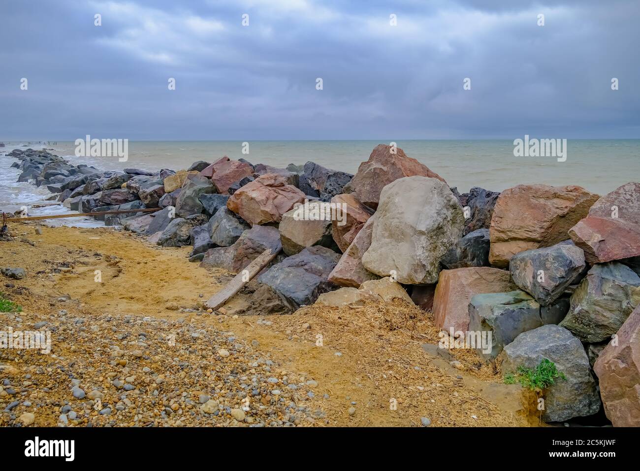 1 Pile of rocks serving as a barrier to protect the sandy cliffs from ...