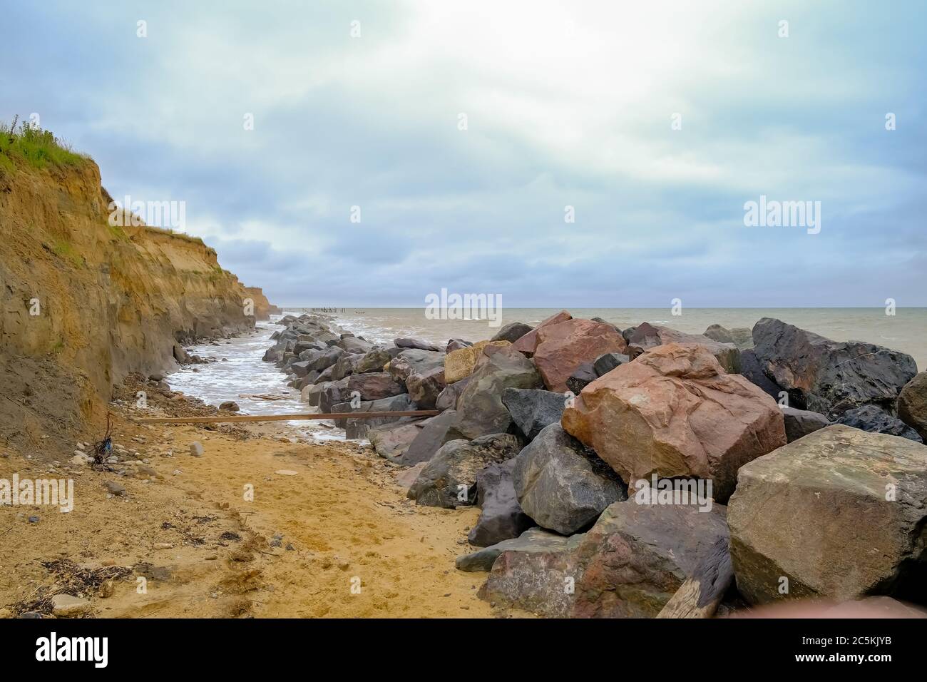 8 A barrier od rocks set down in front of the sandy cliff on ...