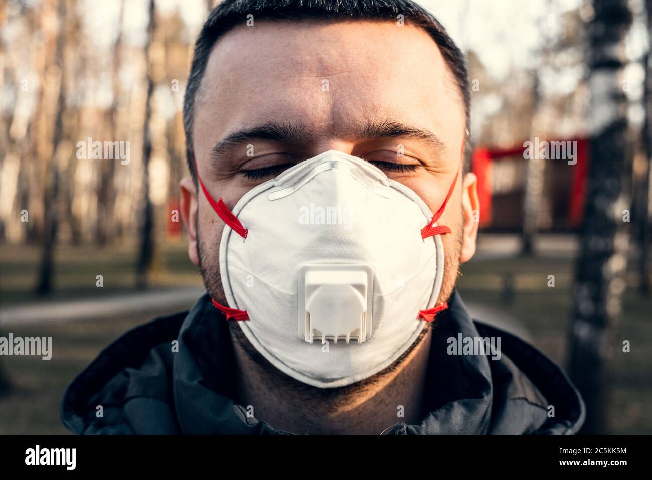 A man in a protective mask in an empty park. Face close up. Quarantine ...