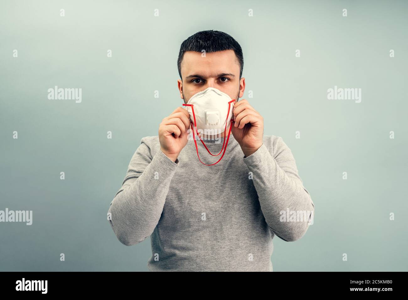 A man is putting on a protective mask. Respiratory protection from ...