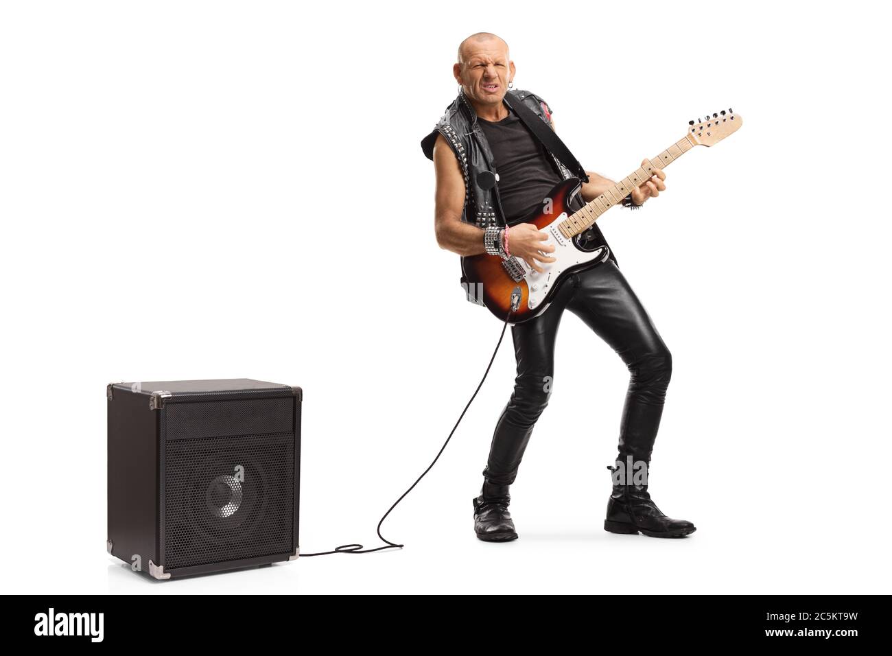 Full length portrait of a bald musician playing a guitar plugged into ...