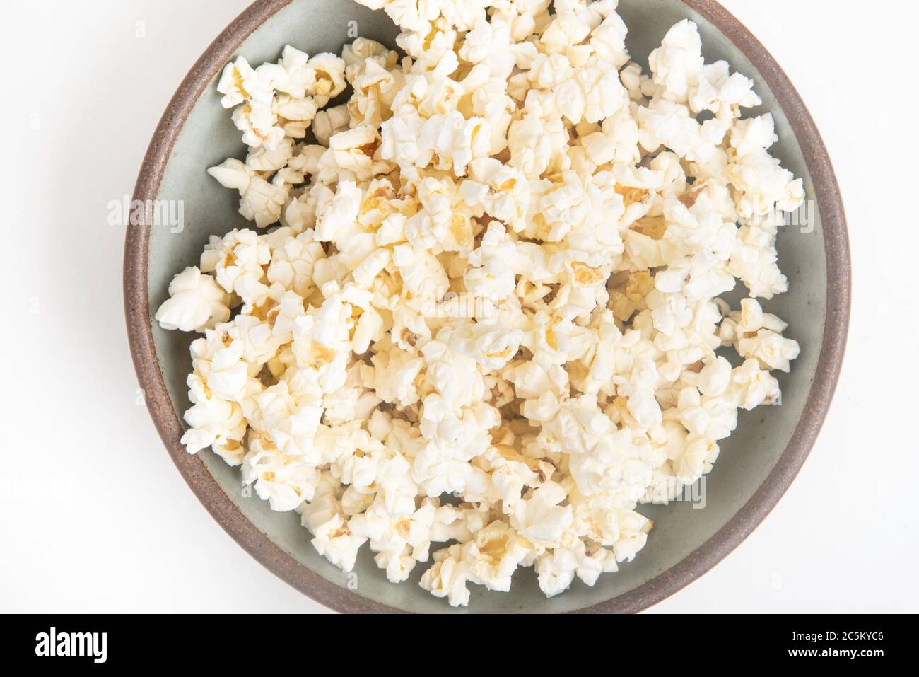 Popcorn in a ceramic bowl set on a plain white background Stock Photo ...