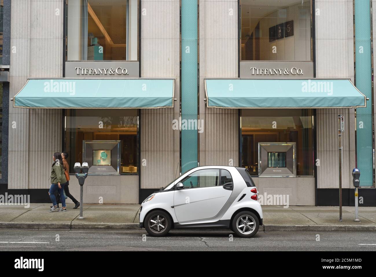 A white and grey Smart car sits parked outside the Tiffany & Co ...