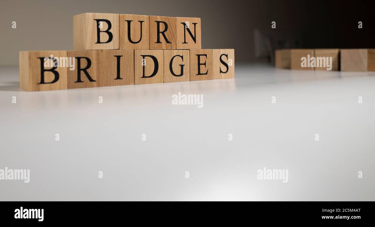 Fighting means leaving, burn bridges. Made of wooden cubes on white ...