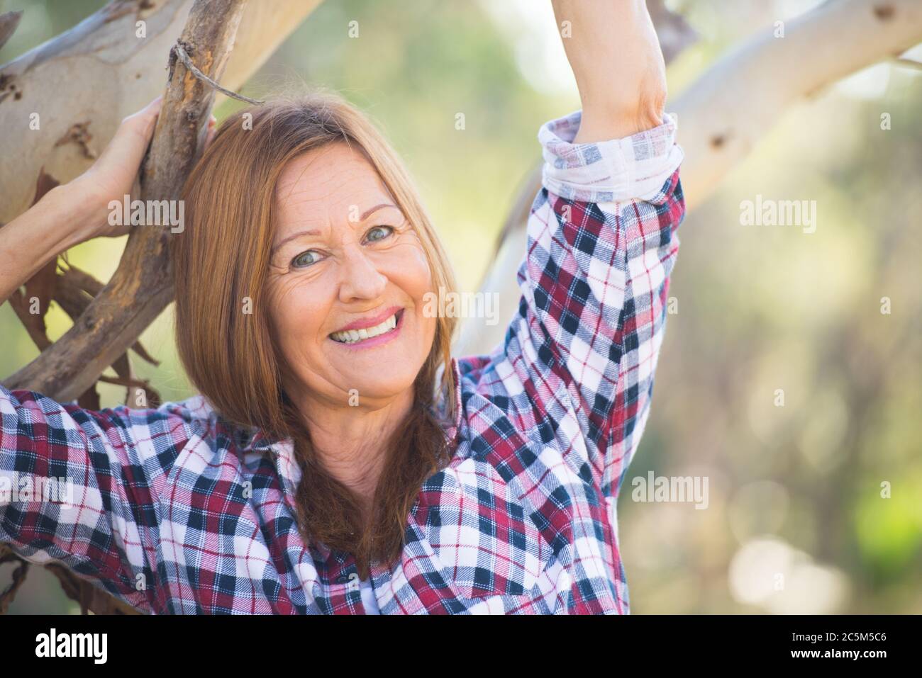 Portrait attractive mature woman in rural country, wearing plaid shirt ...