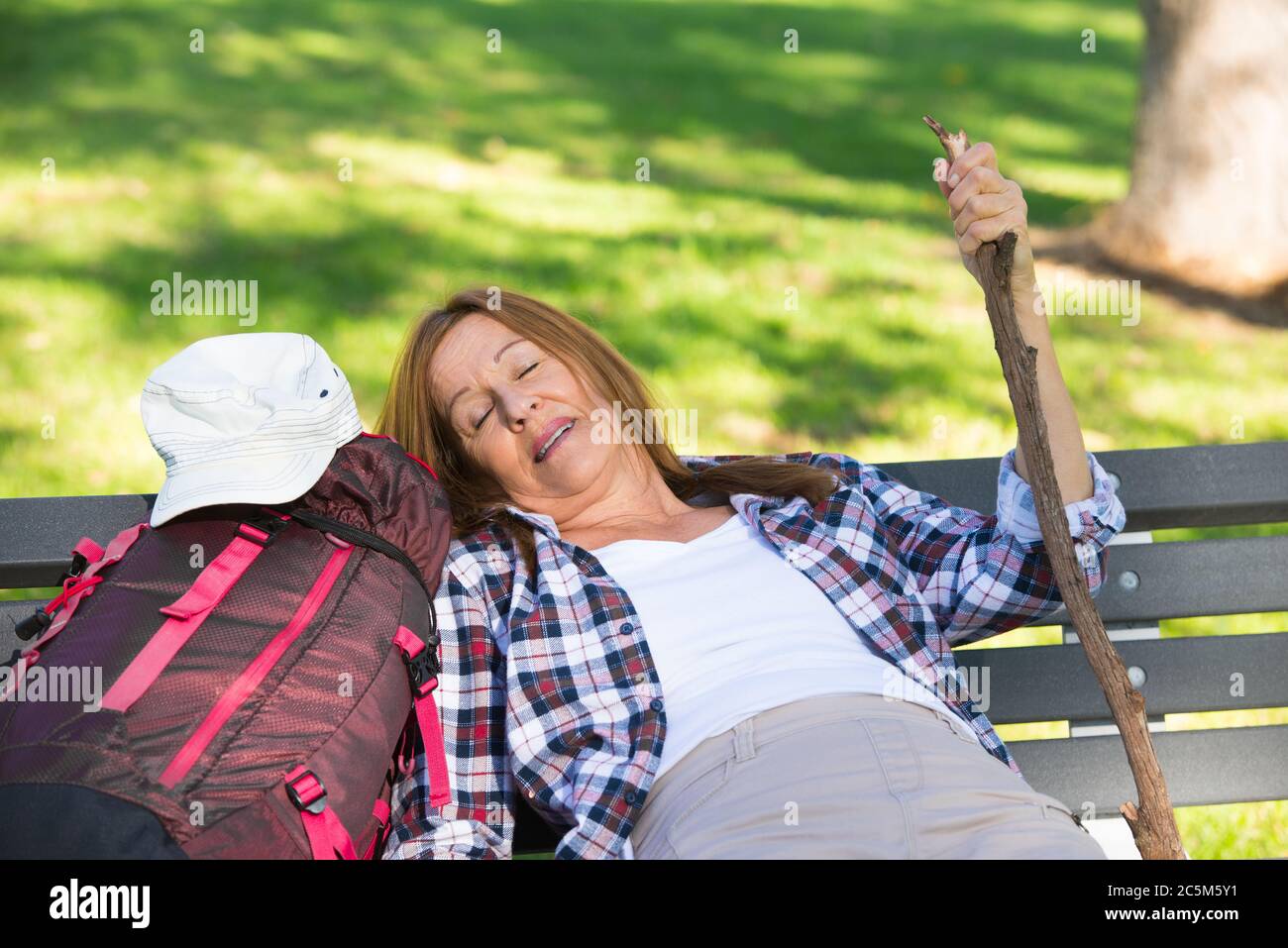 Portrait active attractive mature woman having a rest on bench ...