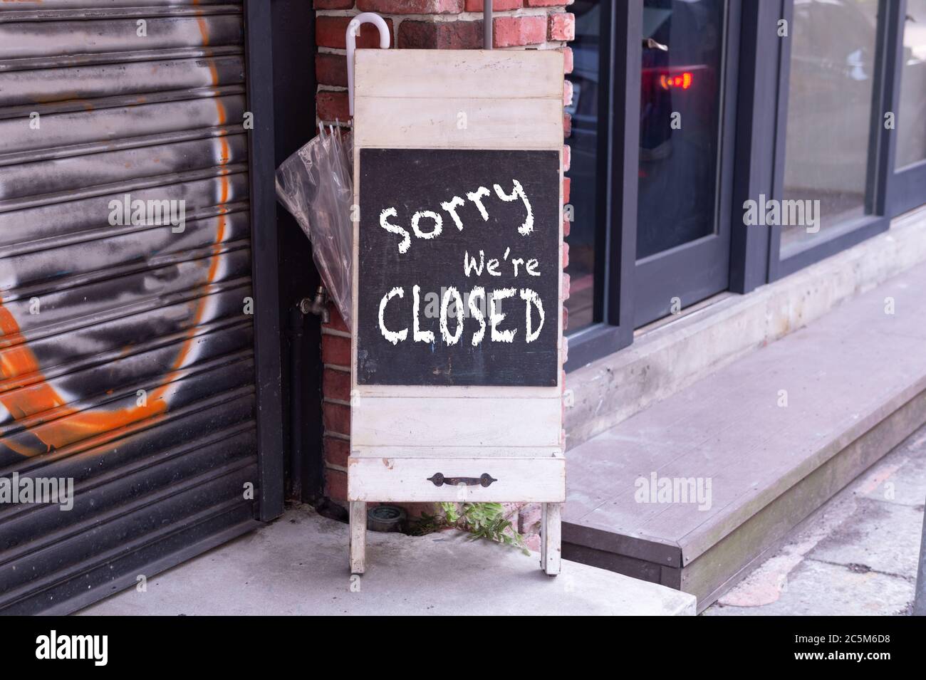 sorry we are closed sign hanging outside a restaurant, store, office or ...